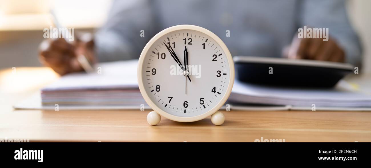 Accountant Calculating Bill With Time Clock Stock Photo - Alamy