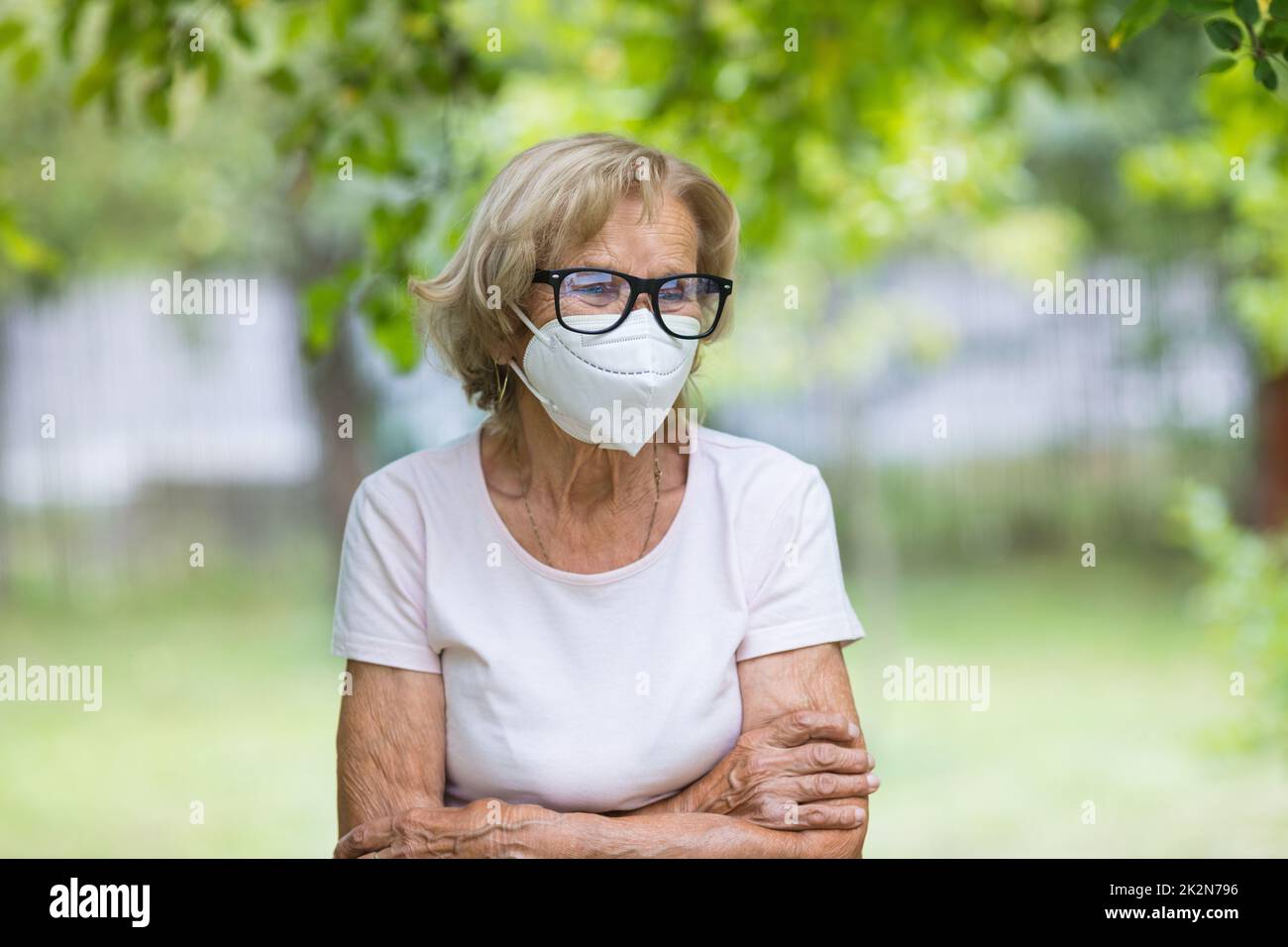 Elderly woman wearing a protective face mask against viruses Stock ...