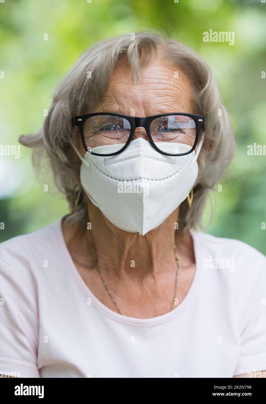 Elderly woman wearing a protective face mask against viruses Stock ...