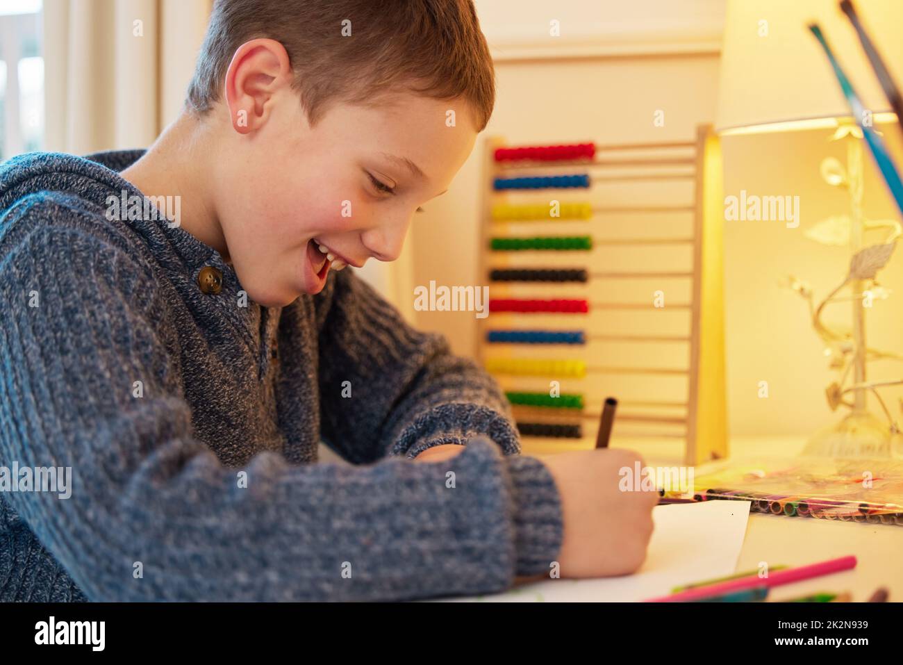 Getting creative while completing his homework. Shot of a young boy ...