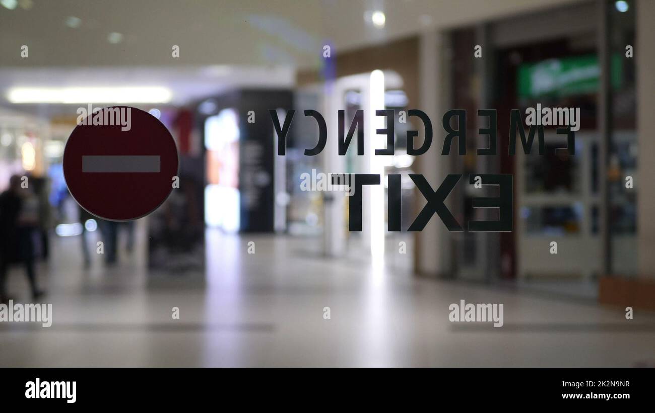 Emergency exit sign on empty city mall during pandemic Stock Photo - Alamy