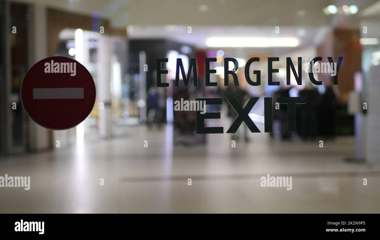 Emergency exit sign on empty city mall during pandemic Stock Photo - Alamy