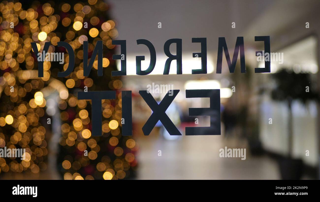 Emergency exit sign on empty city mall during pandemic Stock Photo - Alamy