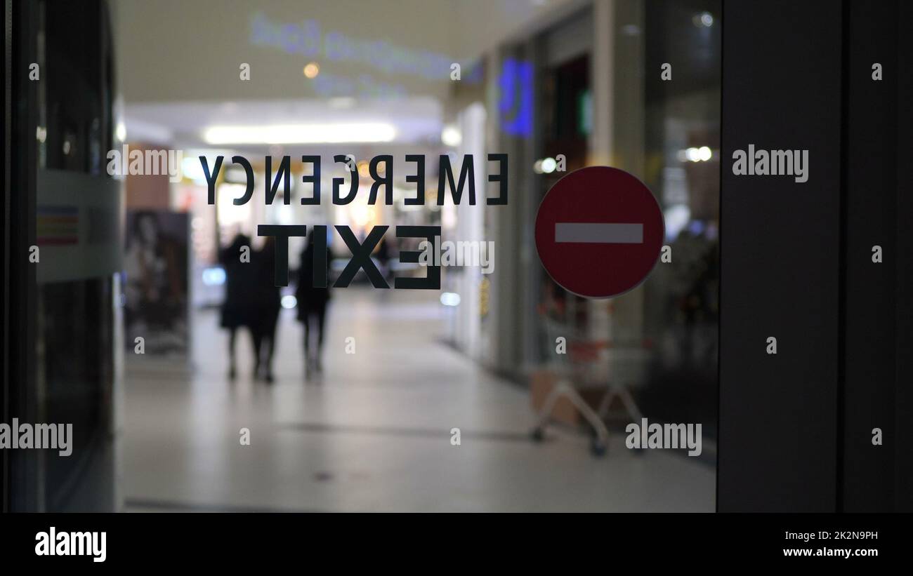 Emergency exit sign on empty city mall during pandemic Stock Photo - Alamy