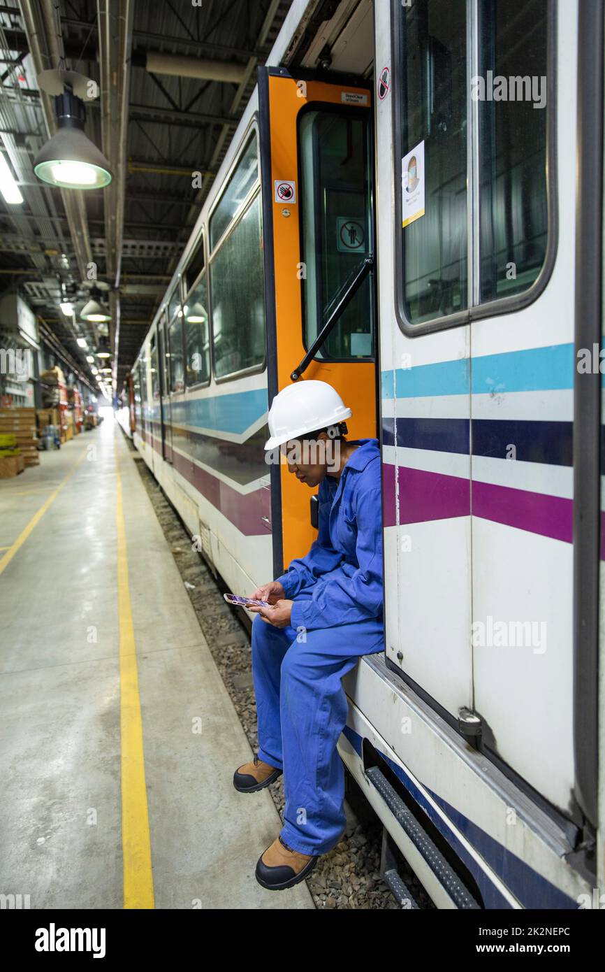 Female transit worker with smart phone taking a break at subway Stock ...