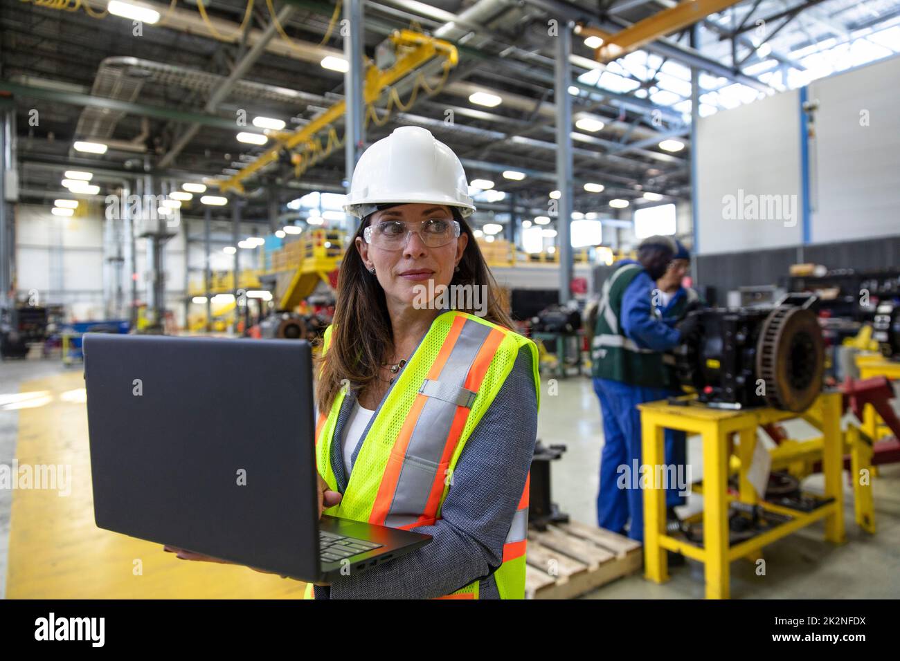 Female transit manager with laptop in maintenance facility Stock Photo ...