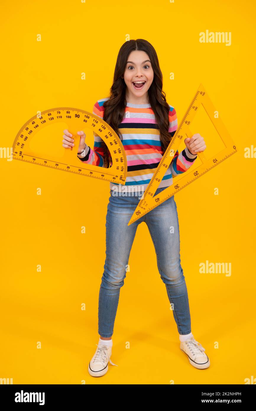 Back to school. School girl hold ruler measuring isolated on yellow ...