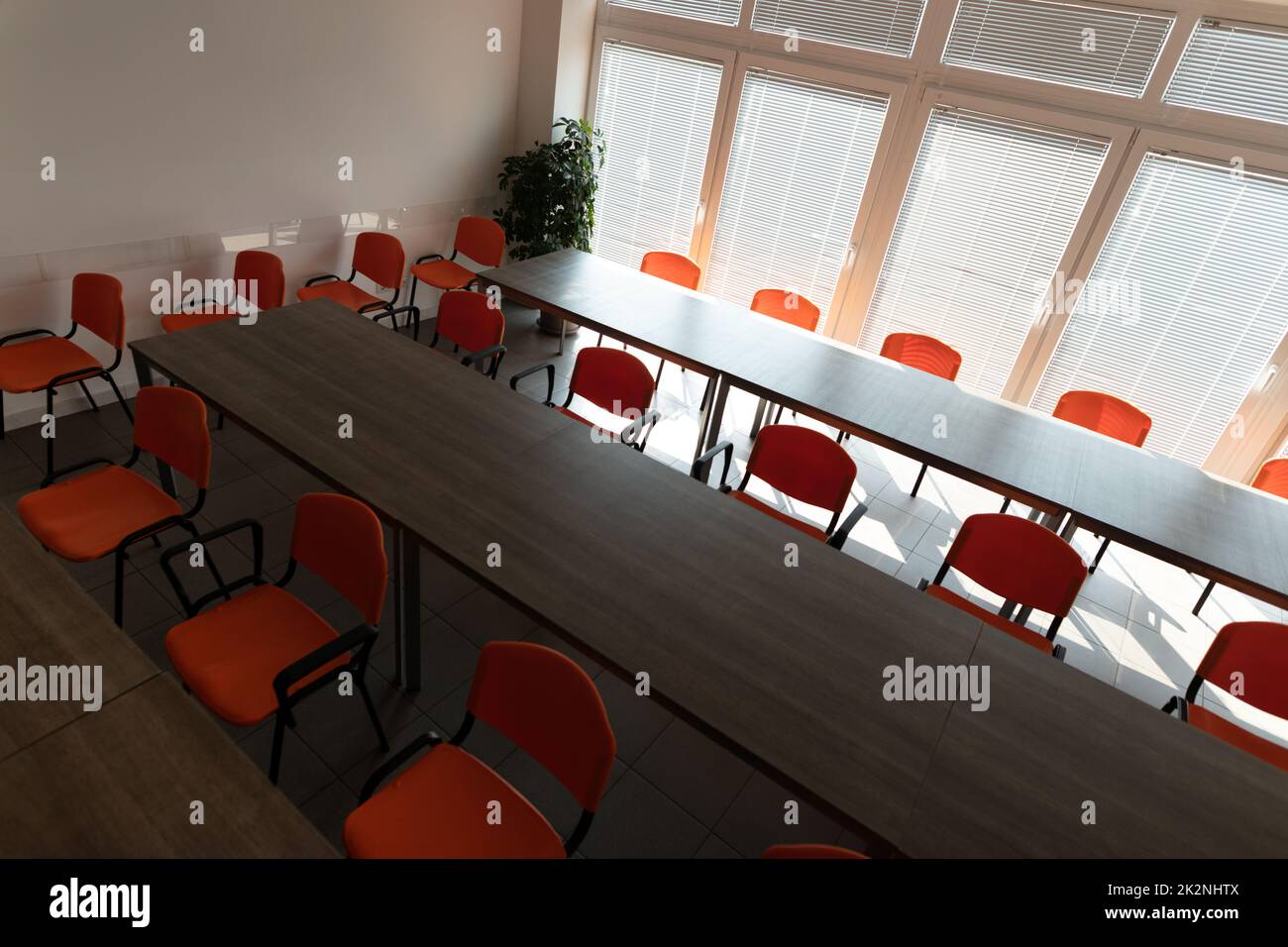 Empty desks and chairs in office conference room Stock Photo - Alamy