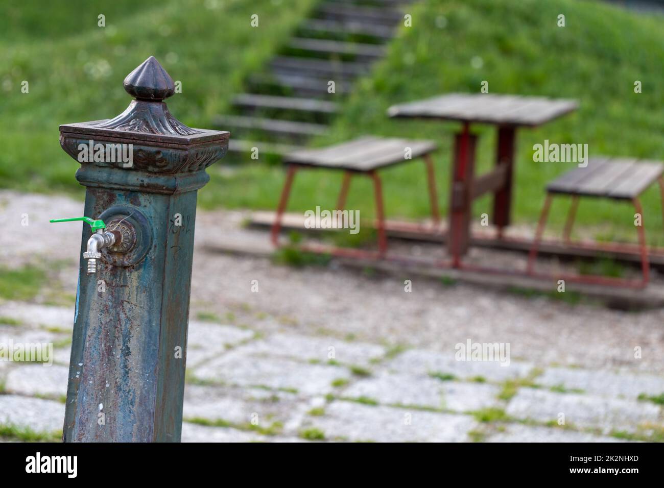 Water fountain and empty tables in an urban park Stock Photo - Alamy