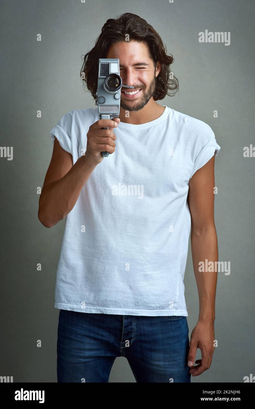 Rolling... and action. Studio portrait of a young man posing with a ...