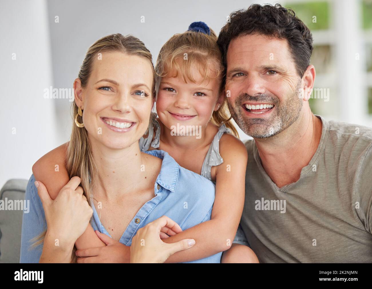 Family, mom and dad with child in their home, sitting and posing in the ...