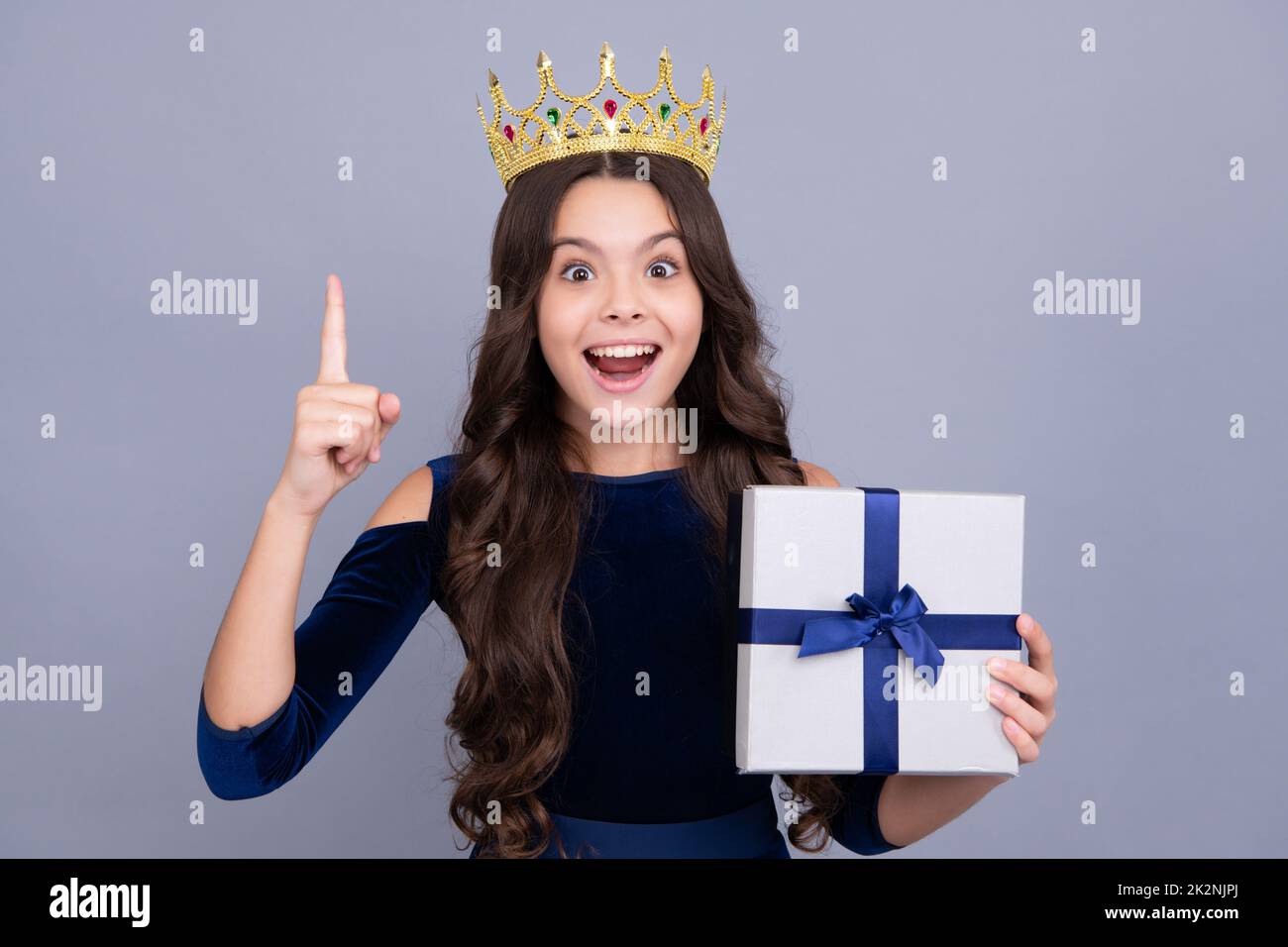 Excited teenager girl princess in crown. Teenager kid with present box ...