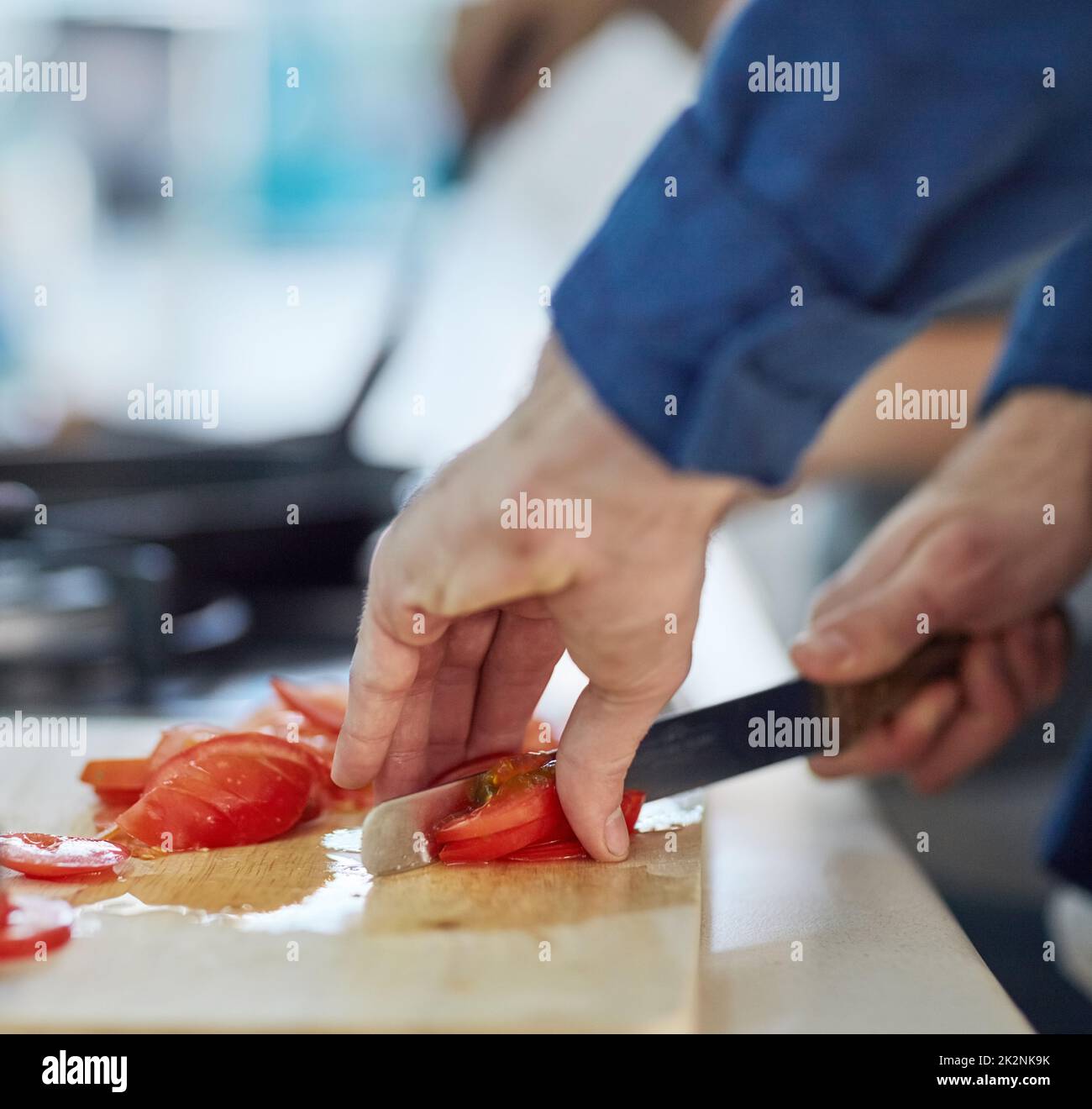 Slicing and dicing. Shot of an unidentifiable man cutting up tomatoes ...