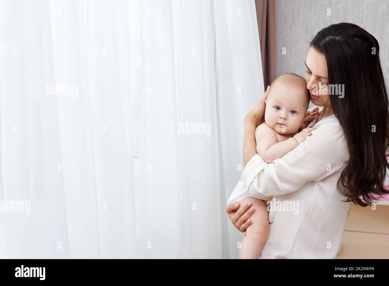 Happy mother holding and hugging adorable newborn baby Stock Photo - Alamy