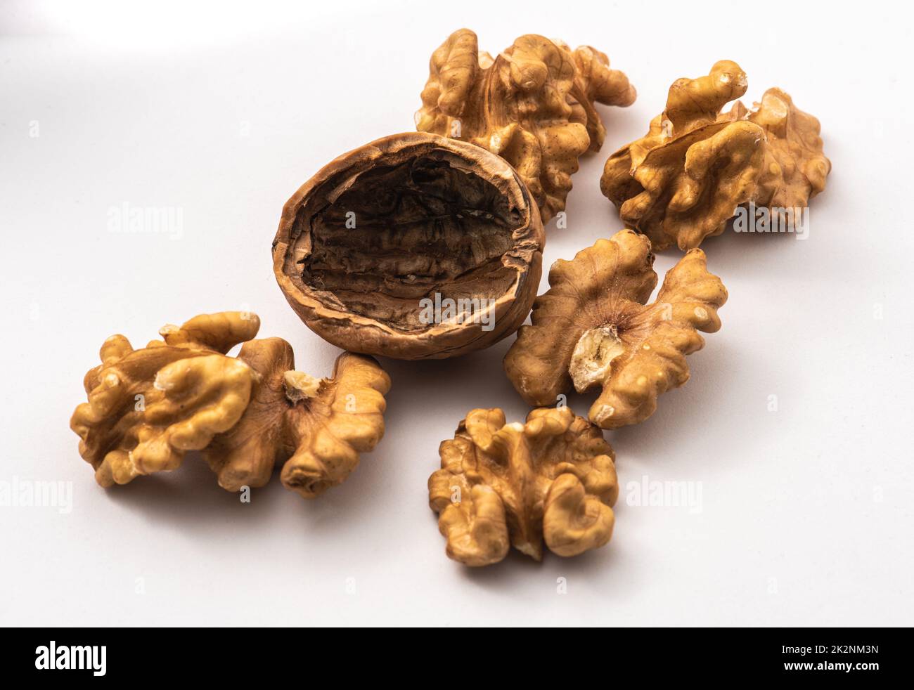 A closeup of brown walnuts and shells isolated on a white background ...