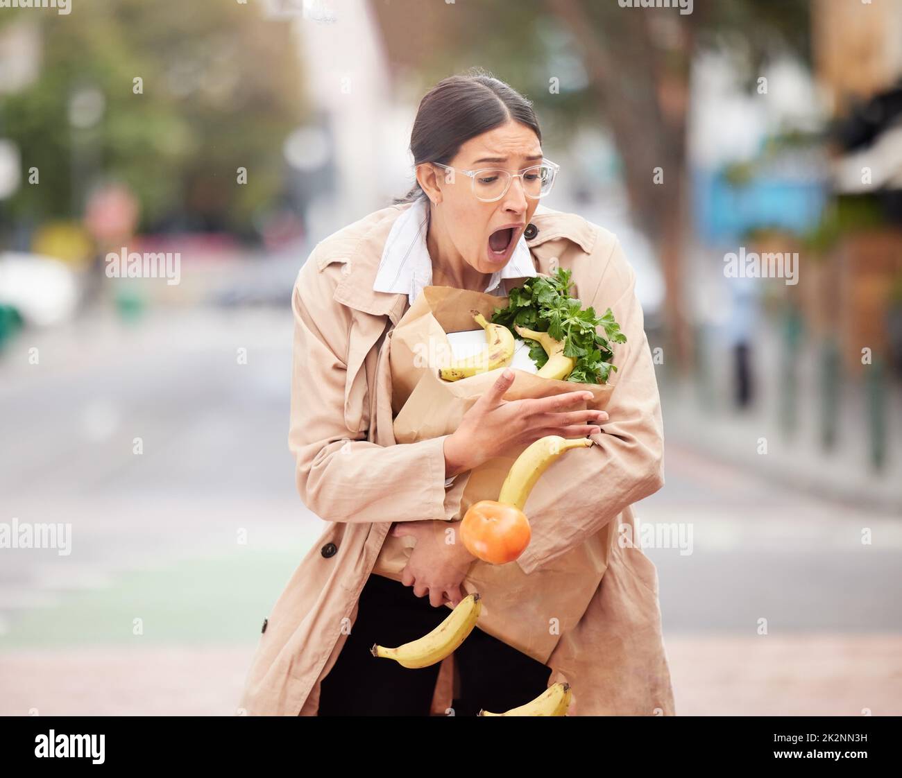 When it rains, it pours. Shot of a beautiful young woman trying to hold ...
