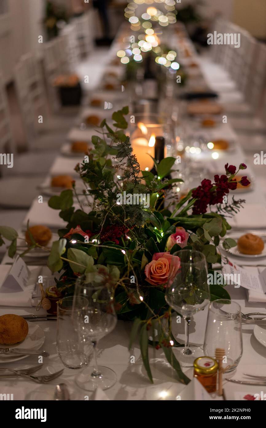 A vertical shot of an arranged wedding reception table with flowers ...