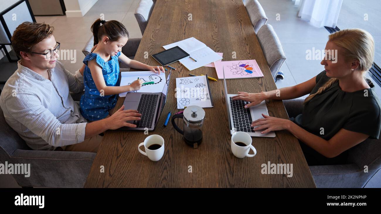 Man, woman and child in home office with laptop, paper documents and ...
