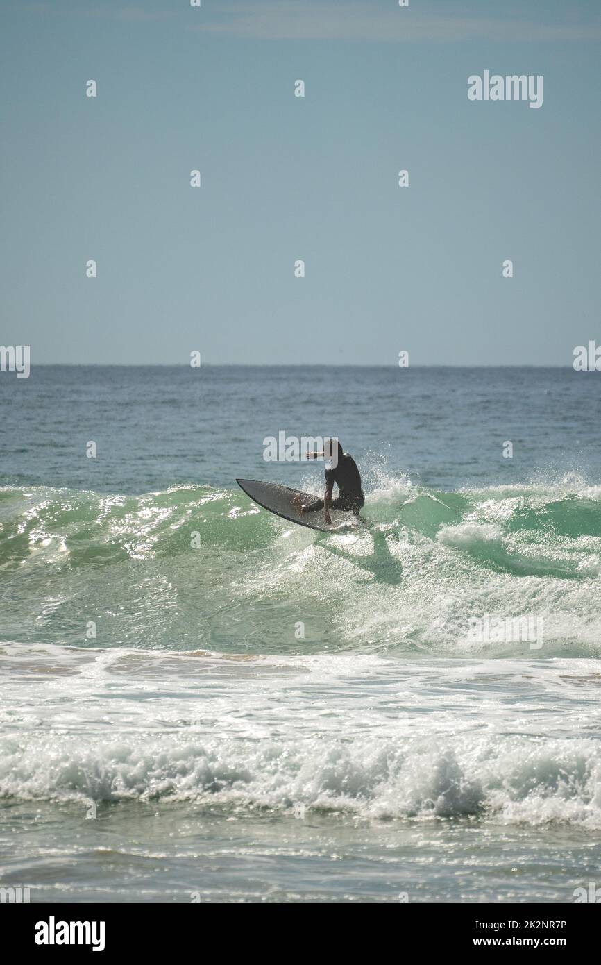 A vertical shot of surfer riding surfboard in ocean Stock Photo - Alamy