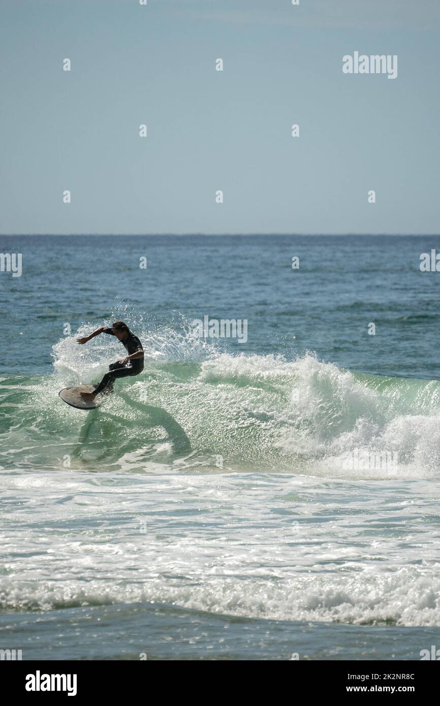 A vertical shot of surfer riding surfboard in ocean Stock Photo - Alamy