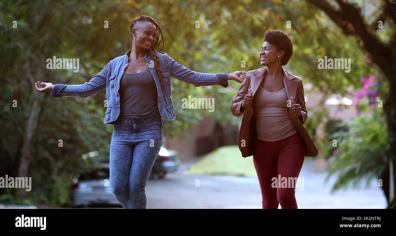 Two women celebrating news outside dancing. African black ethncity ...