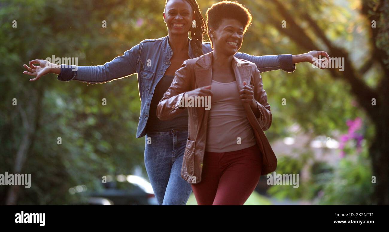 Two women celebrating news outside dancing. African black ethncity ...