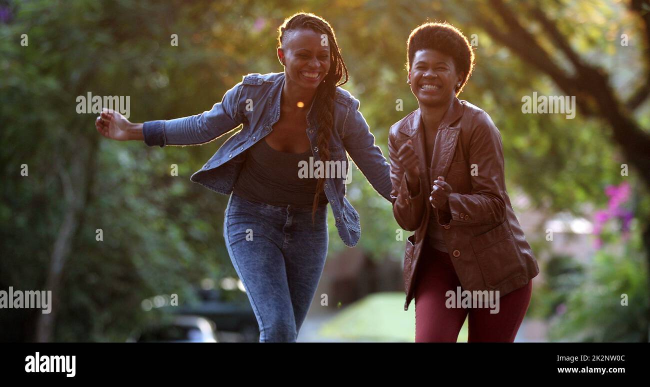 Two women celebrating news outside dancing. African black ethncity ...