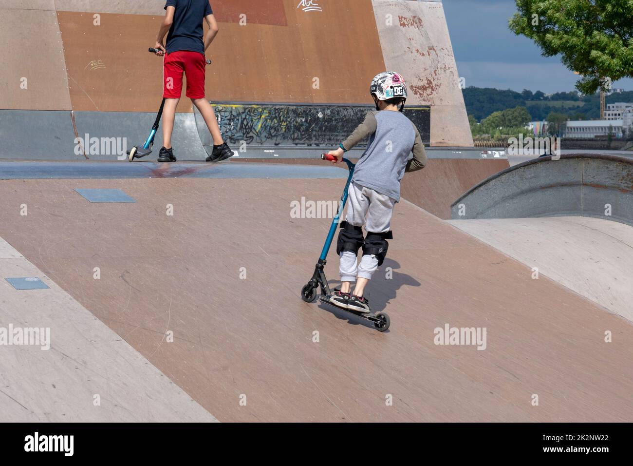 The young kids on scooters performing tricks on the ramp Stock Photo ...