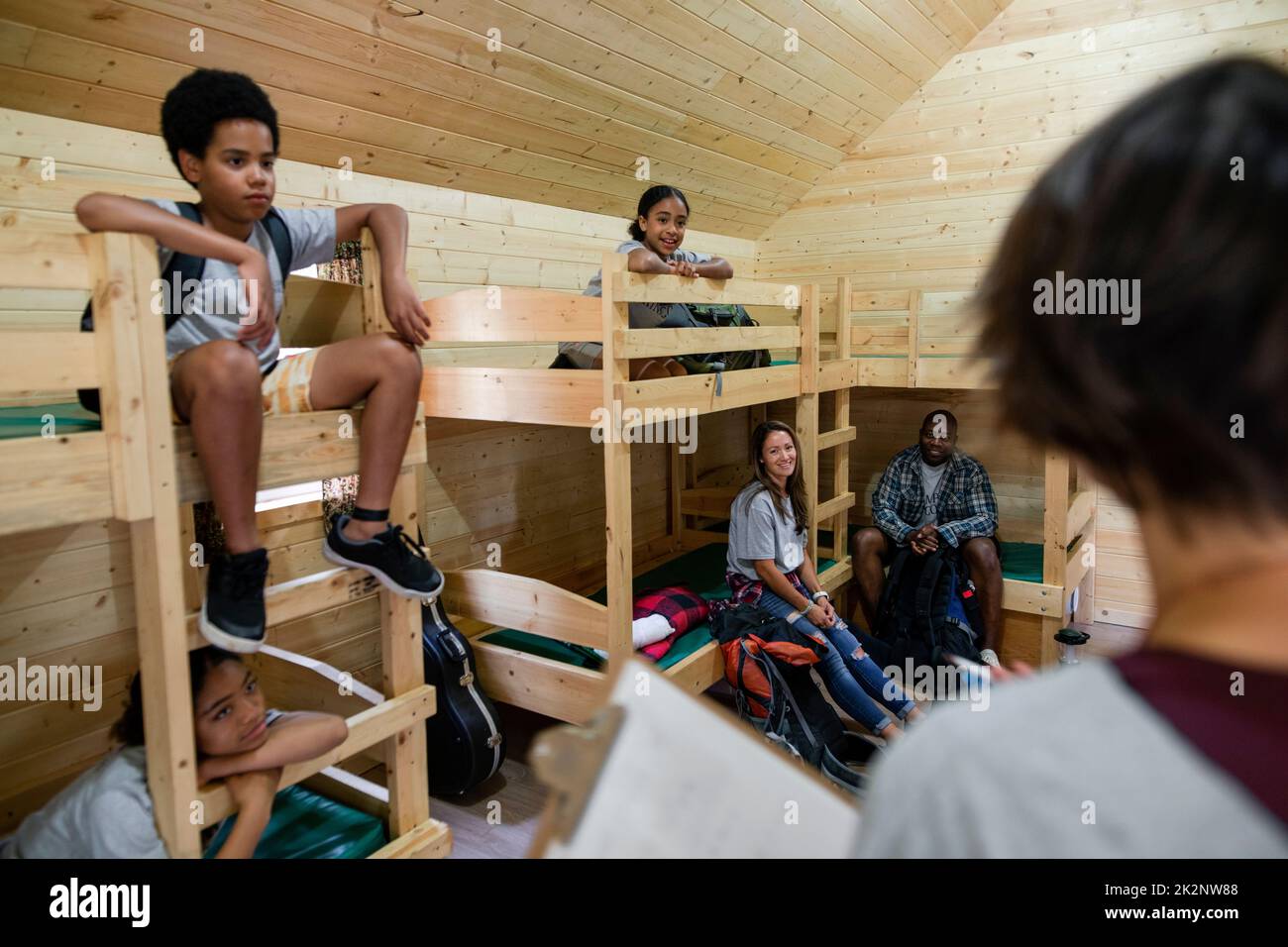 Camp counselor reading aloud from clipboard to family in cabin Stock ...