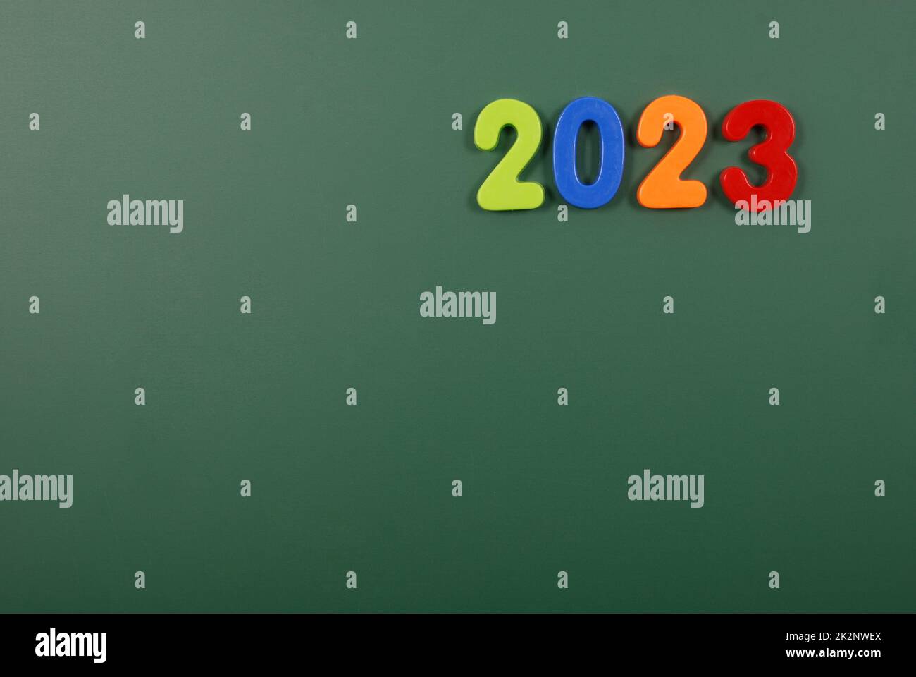 2023 year written in bright plastic magnetic letters stuck on a ...