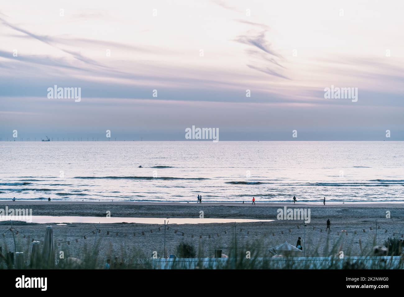 The sandy beach with people walking around Stock Photo - Alamy
