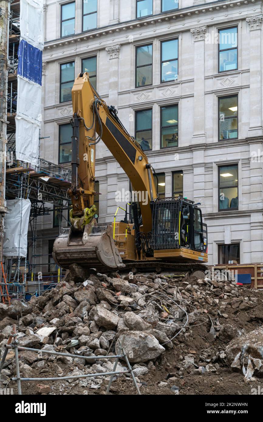 A backhoe on top of stacked rocks in a construction site Stock Photo ...