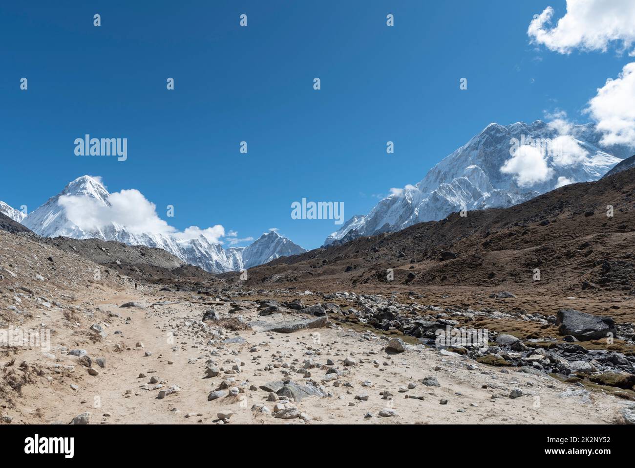 A beautiful view of a desert with a snowy mountain under cloudy sky ...