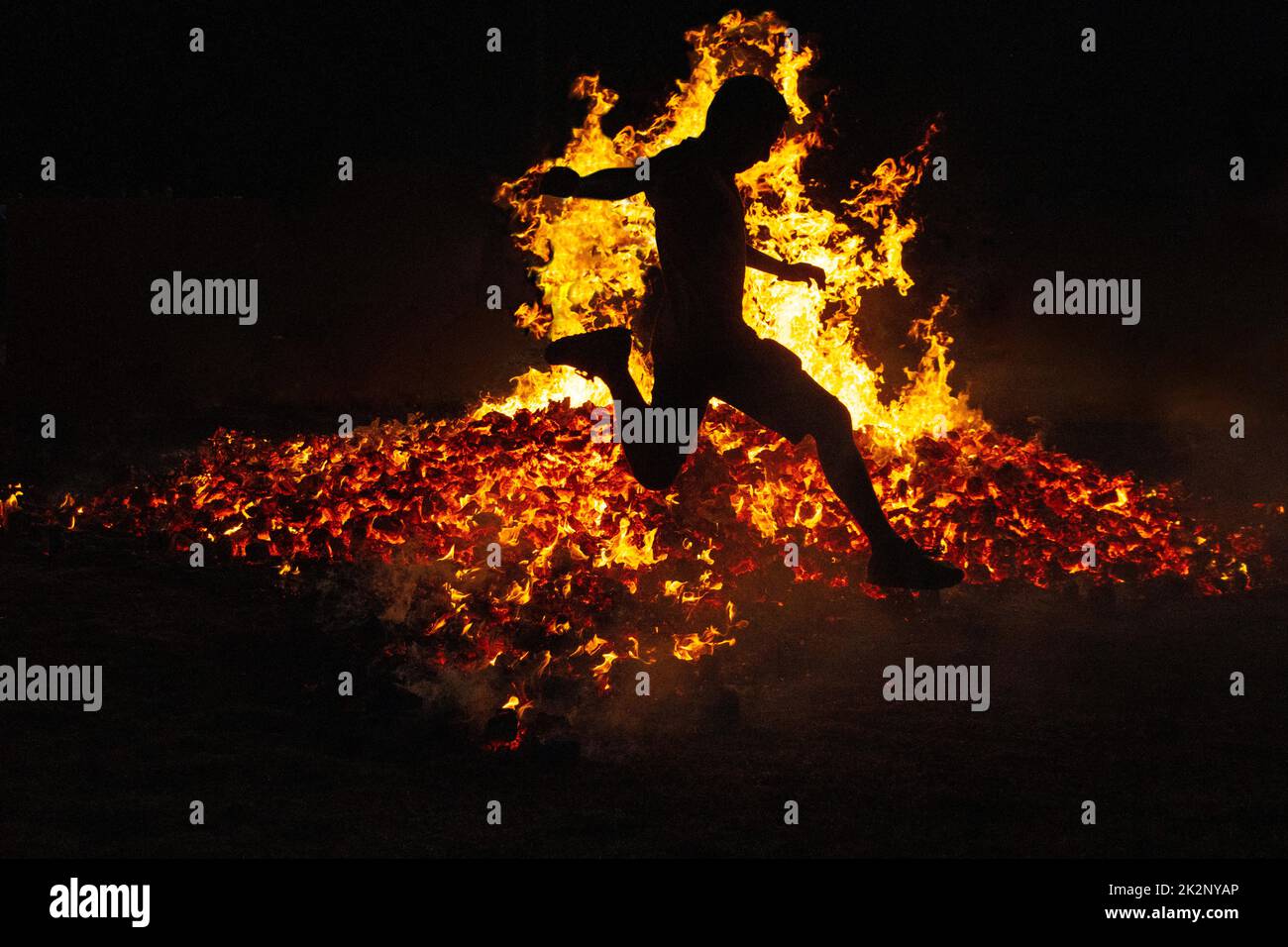 Summer solstice celebration jumping into the fire. Burning flames ...