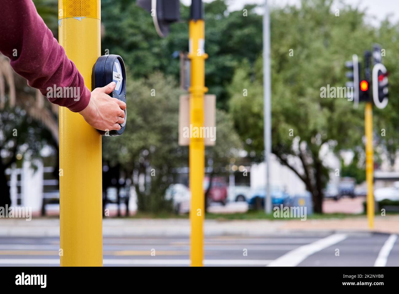 Waiting to walk. Shot of a mans hand pressing the crossing button at an ...