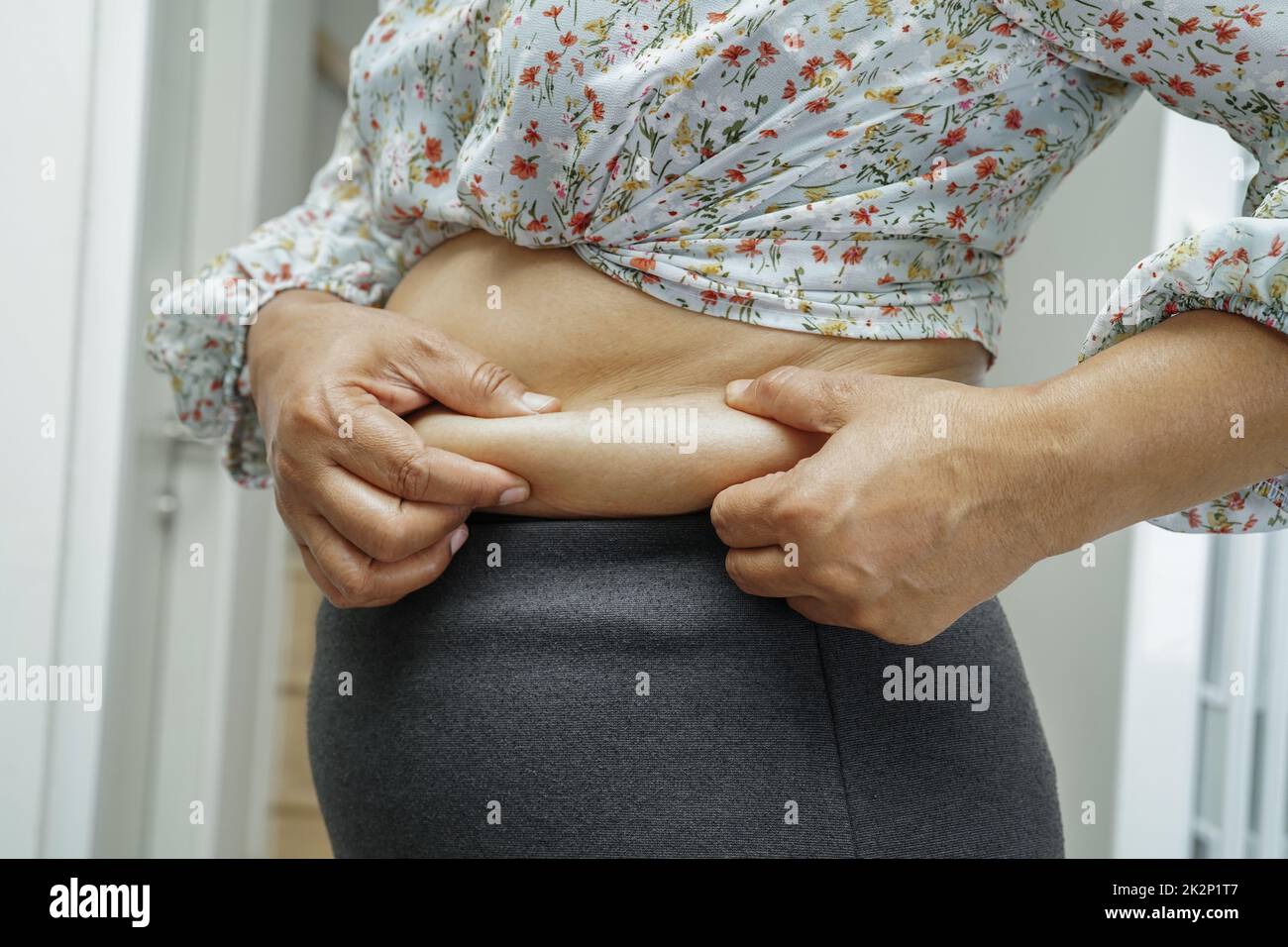 Overweight asian woman use hand to squeeze fat belly big size ...