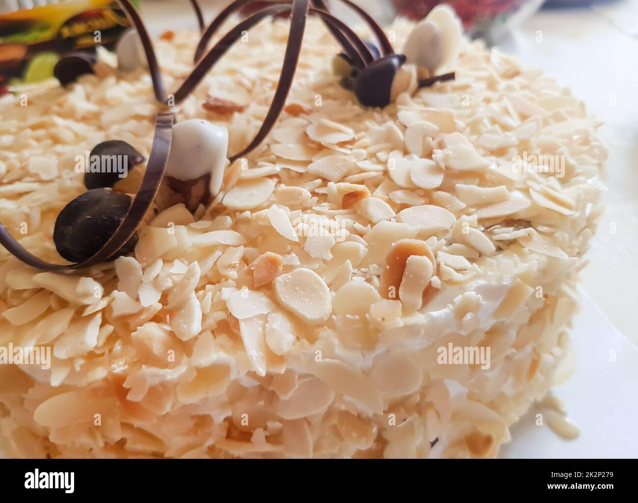 A whole round almond cake decorated with chocolate stripes and nuts ...