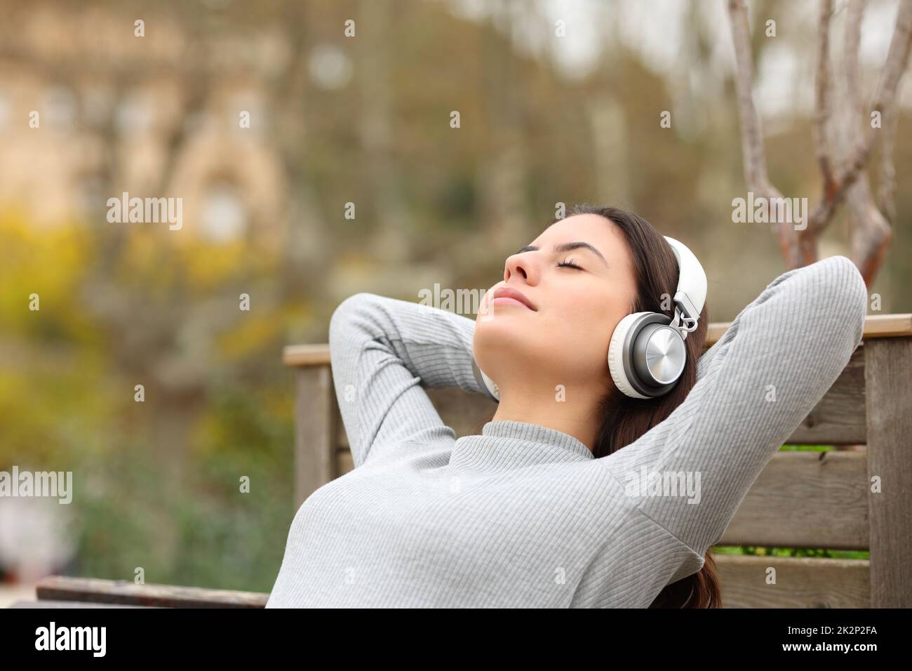 Relaxed teen resting listening to music in a bench Stock Photo - Alamy
