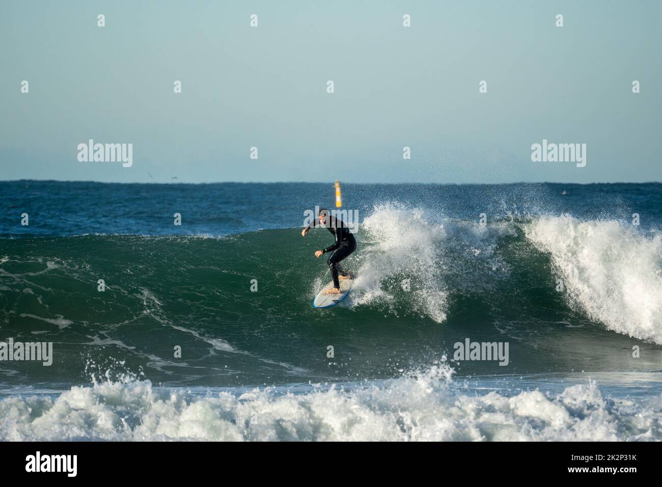 A young surfer catching waves before work on an early Friday morning at ...