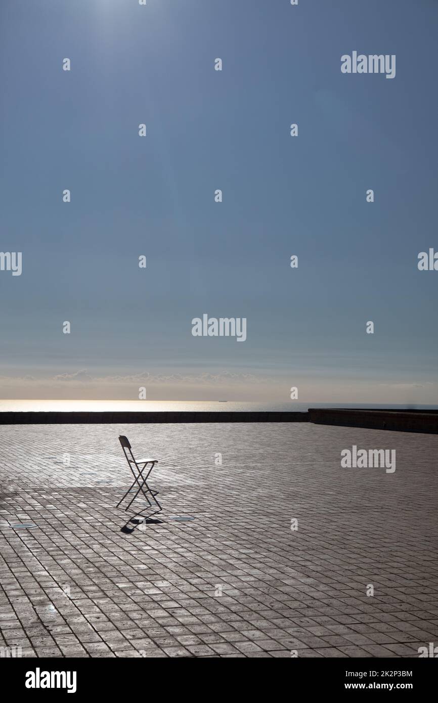 A wooden chair standing in the middle of an empty stage. Loneliness ...