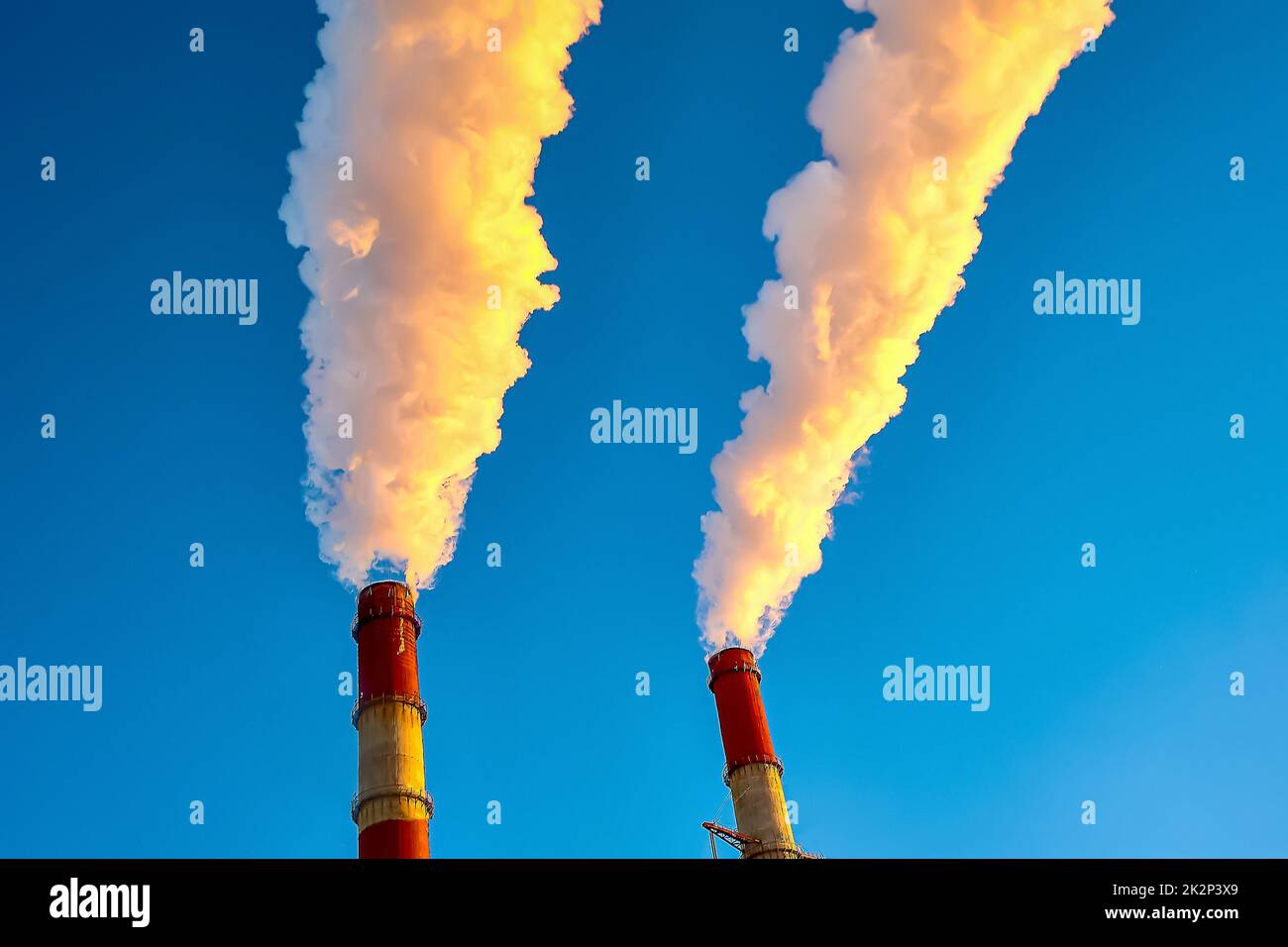 white smoke is coming out of the pipes in the blue sky Stock Photo - Alamy