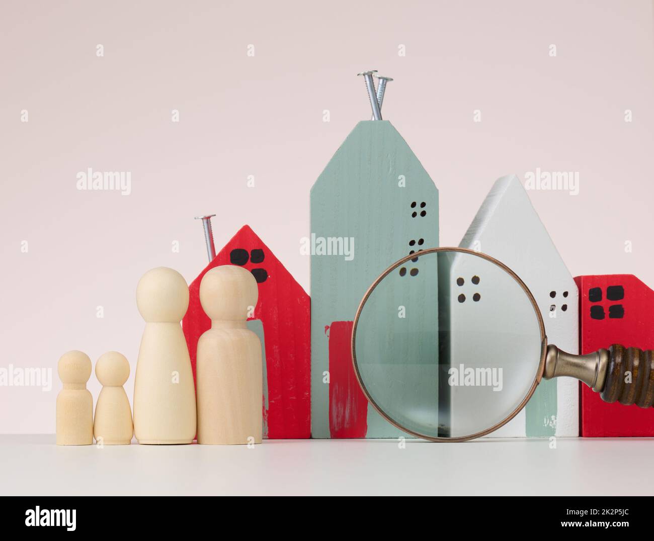 Magnifier and wooden house on a brown background. Real estate rental ...