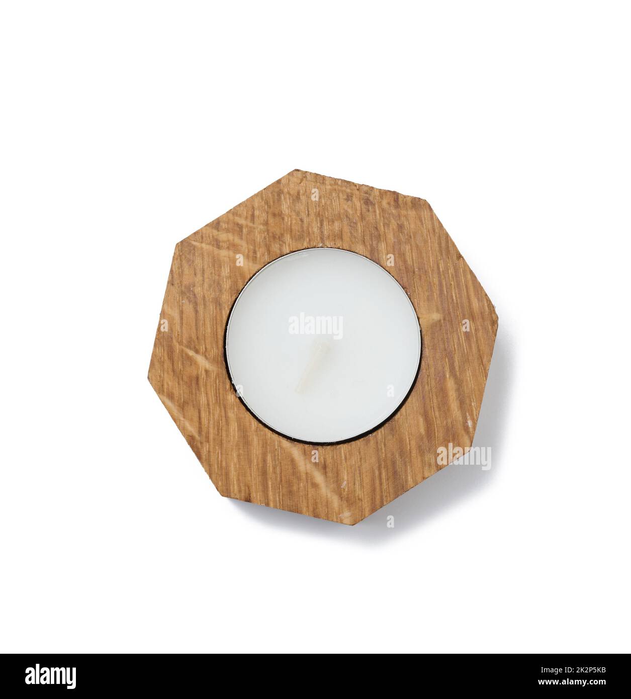 round white candle in a wooden candlestick on a white isolated ...
