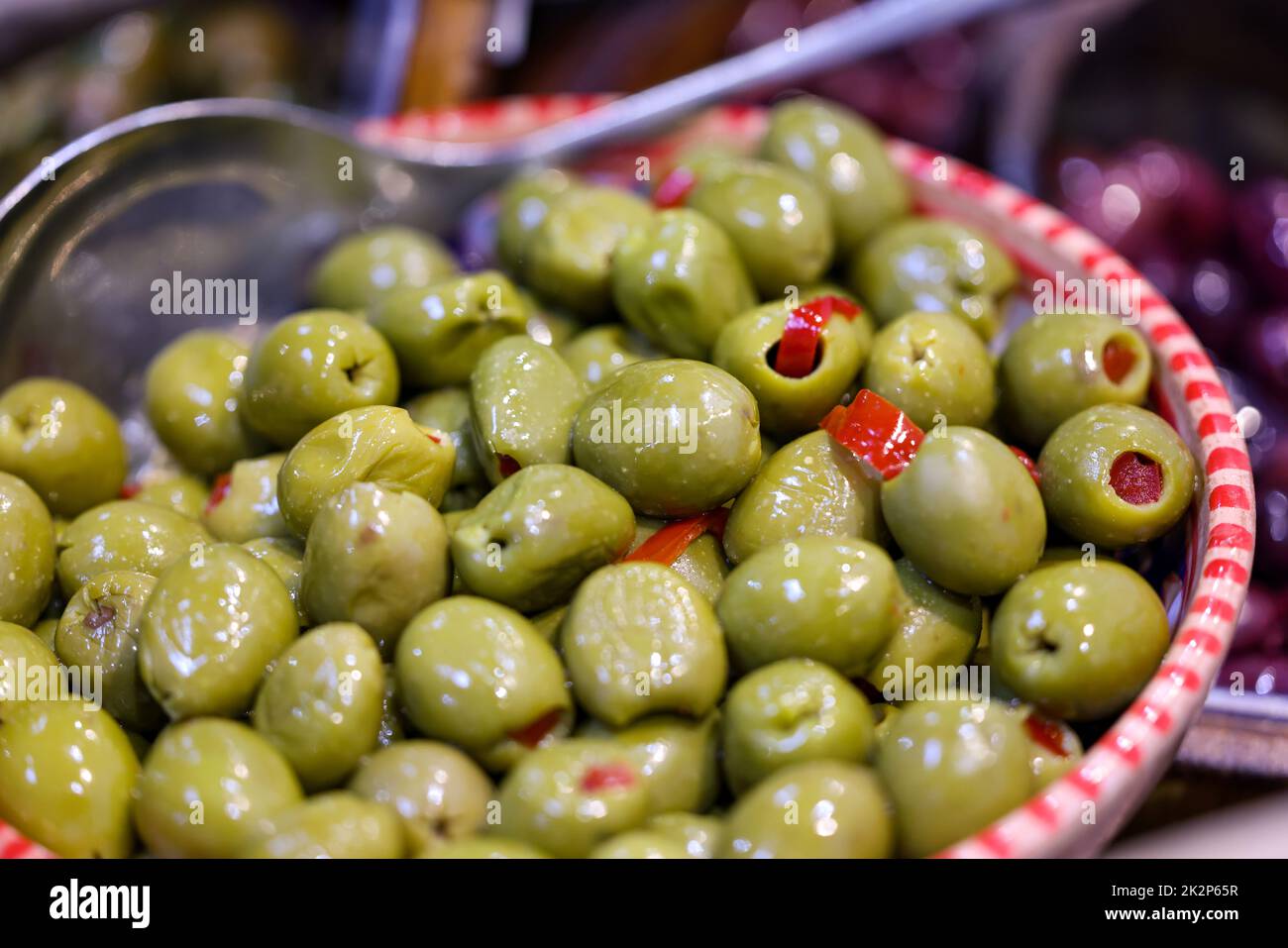 Stuffed green olives in an old wooden bowl Stock Photo - Alamy