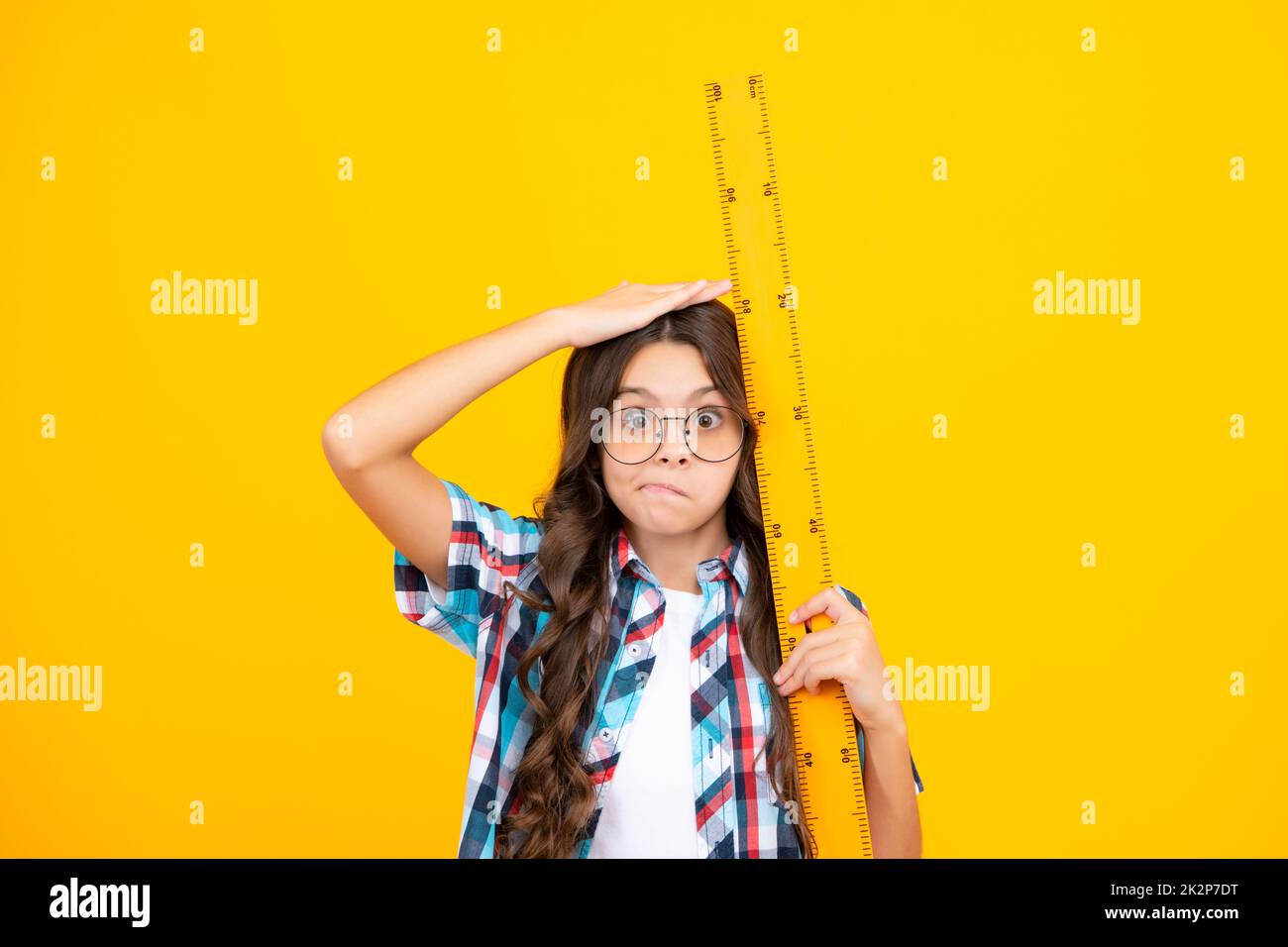 Kid height measure, growth measurement. Funny face. School girl holding ...
