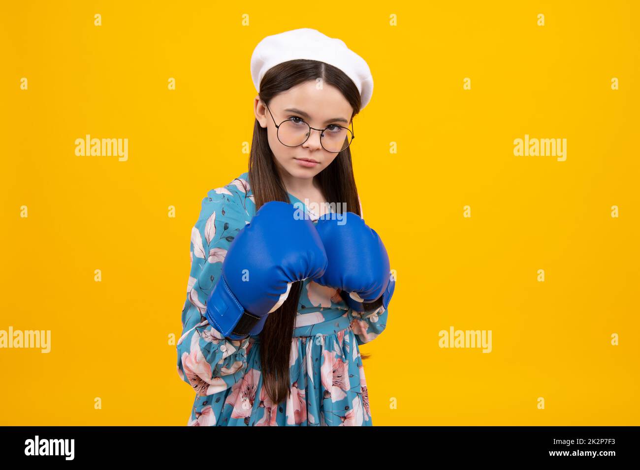 Portrait of a cute teenage boxer girl on yellow isolated background ...
