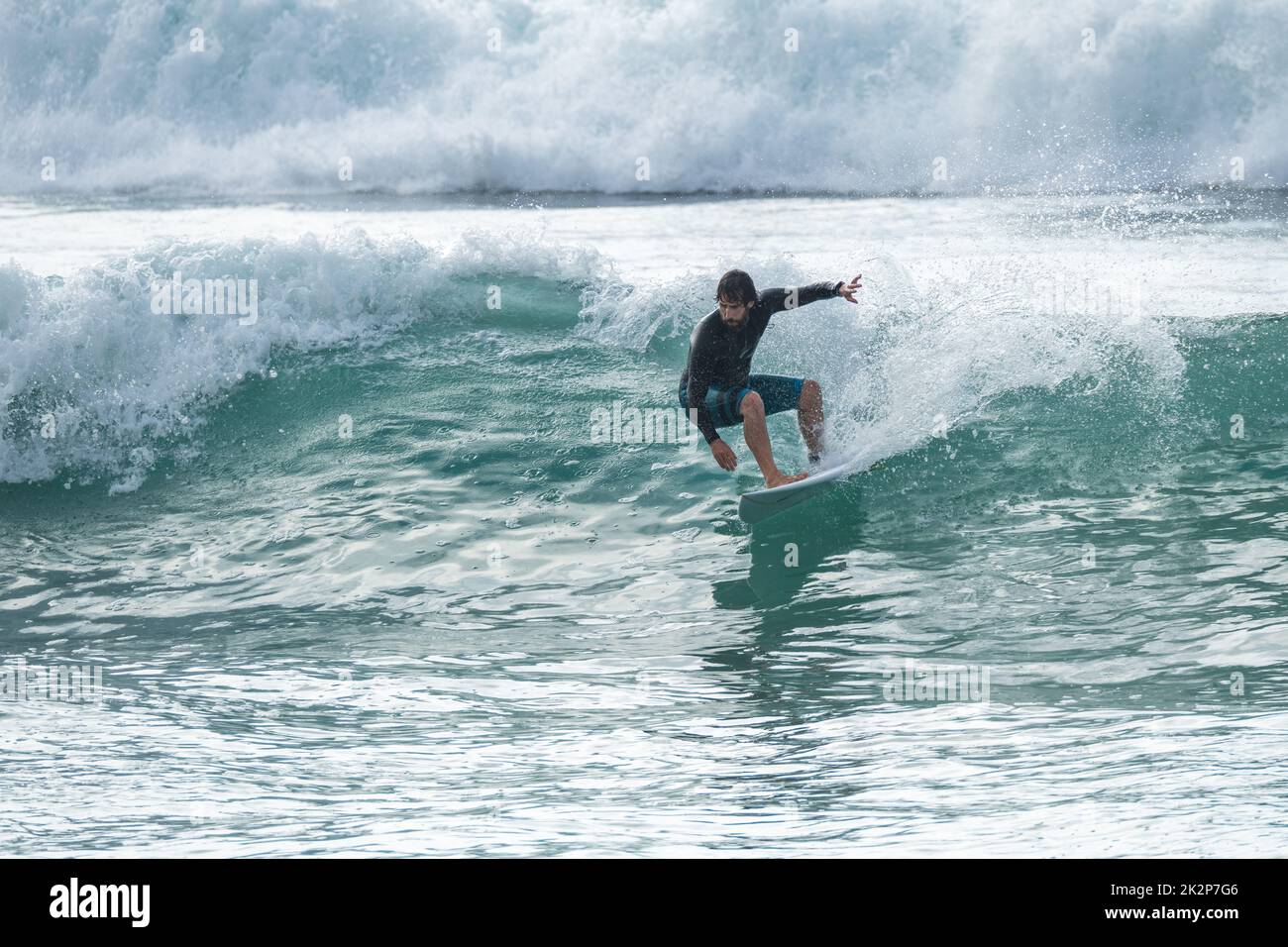 Local surfer riding waves with a short board in Furadouro beach ...