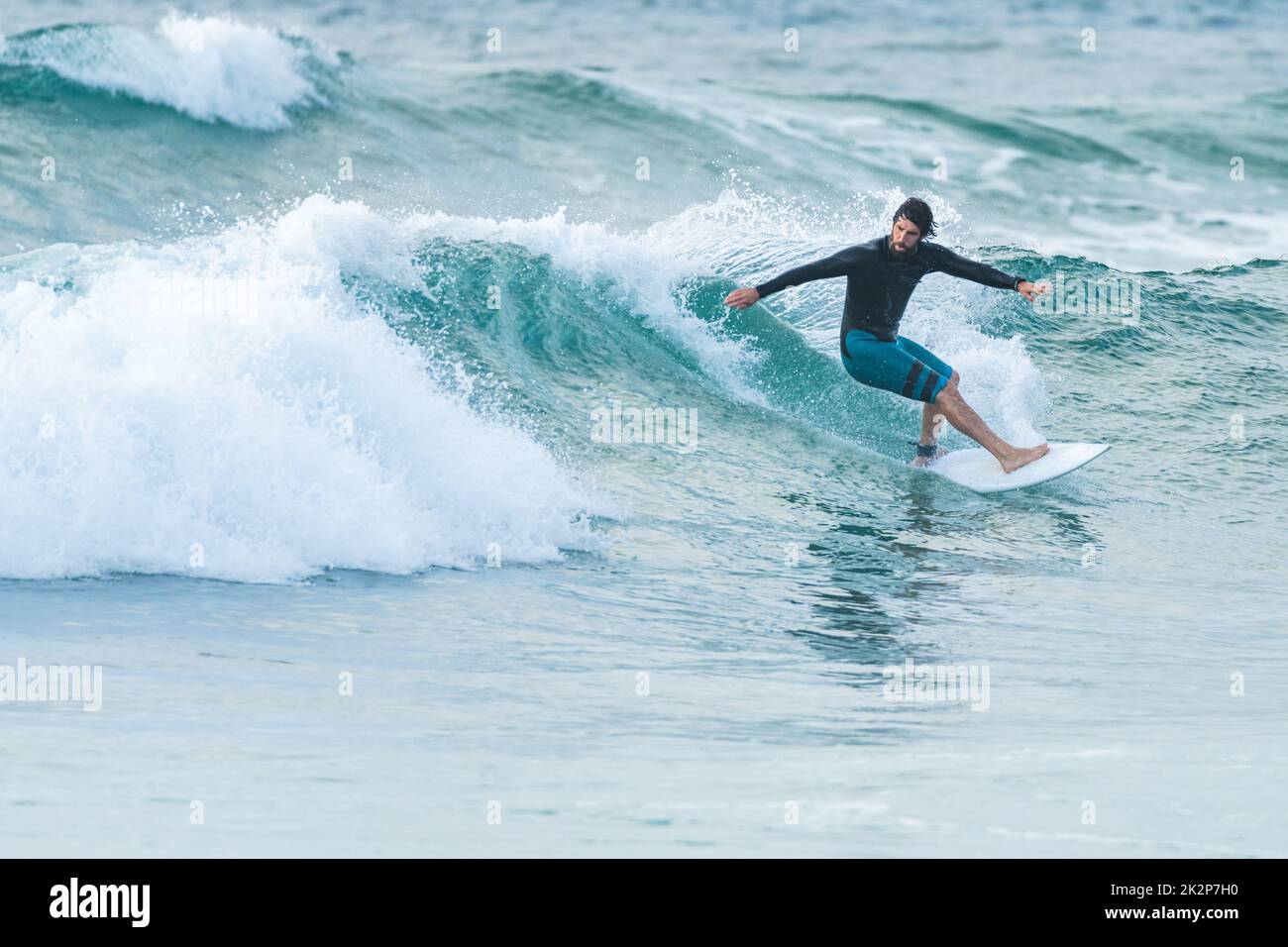 Local surfer riding waves with a short board in Furadouro beach ...