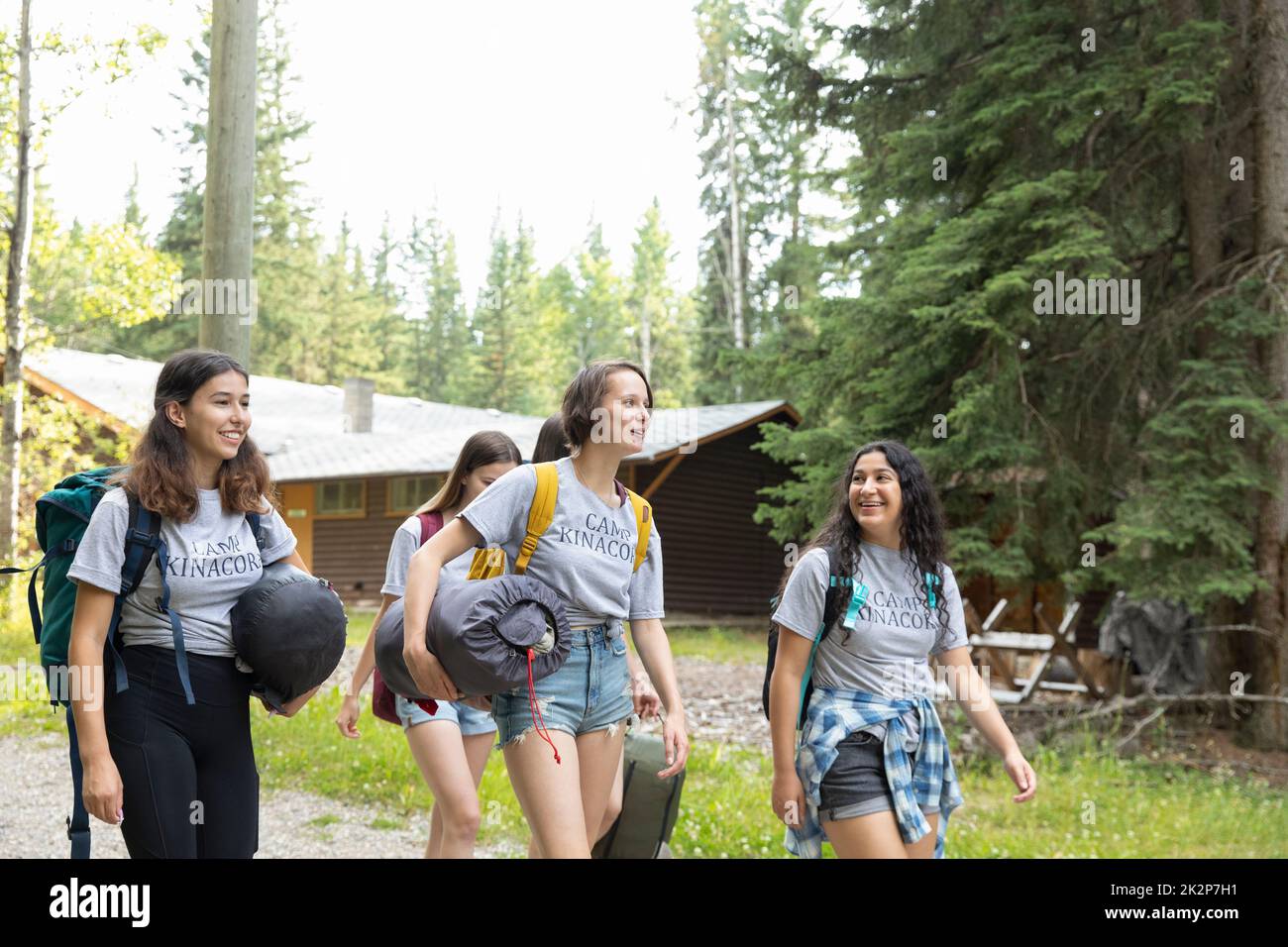 Girls with backpacks walking through summer camp Stock Photo - Alamy