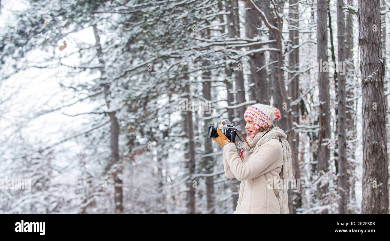 Taking stunning winter photos. Winter hobby. Enjoy beauty of snow scenery through photos. Woman ...